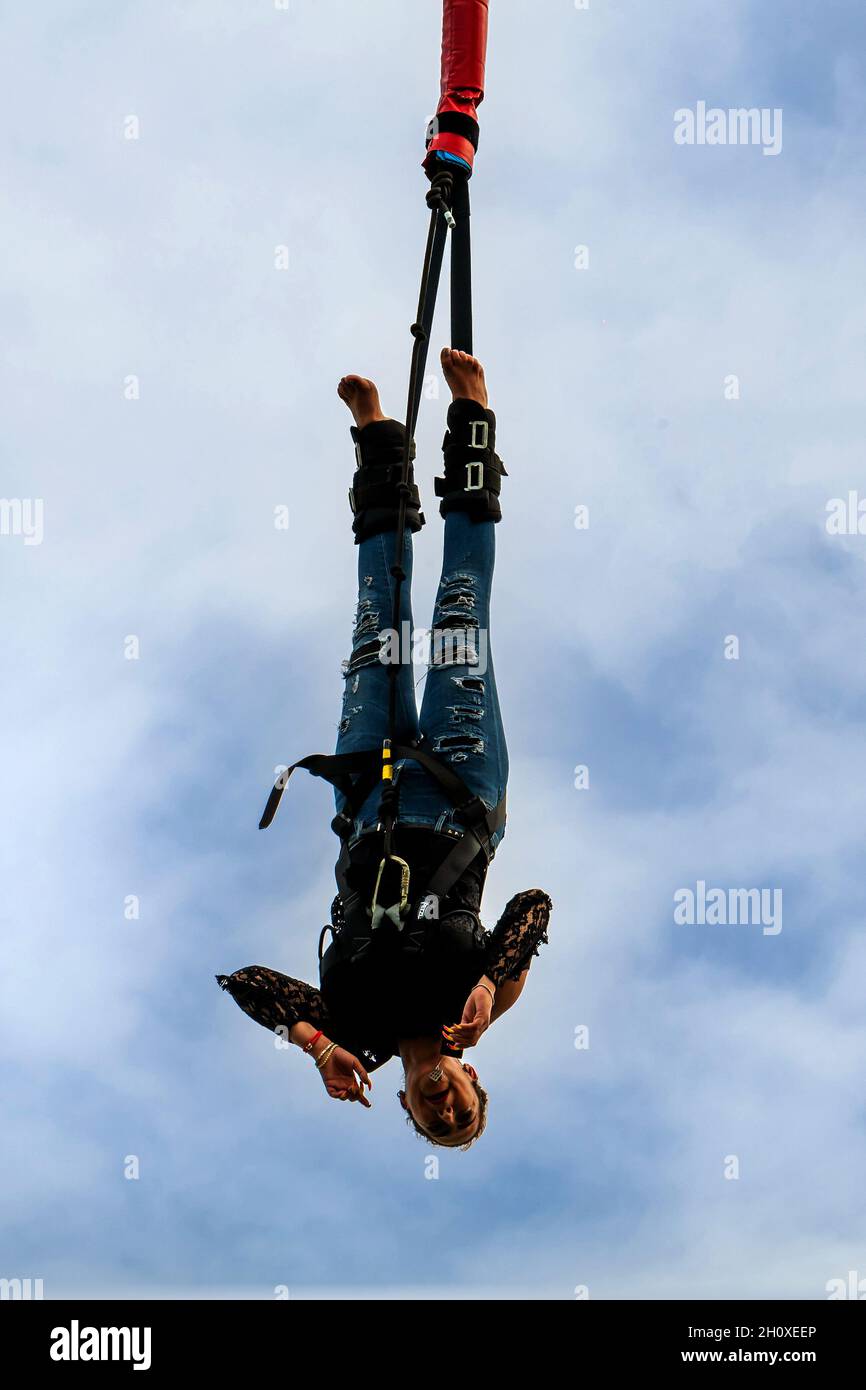Bungy jumper jumping from a high bridge over the void and down to the ...