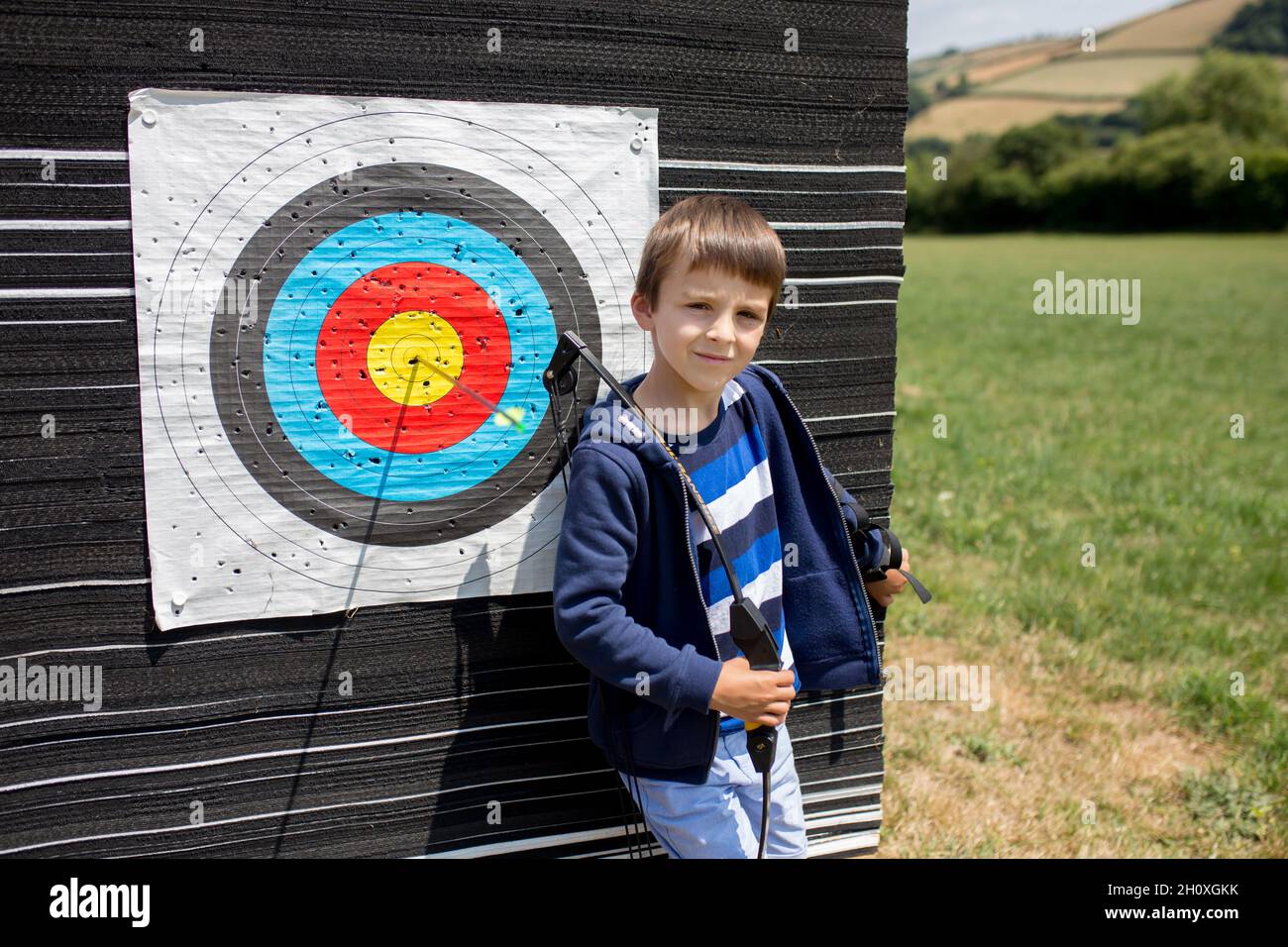 Proud boy, shooting bow and arrow at target, being successful right in ...