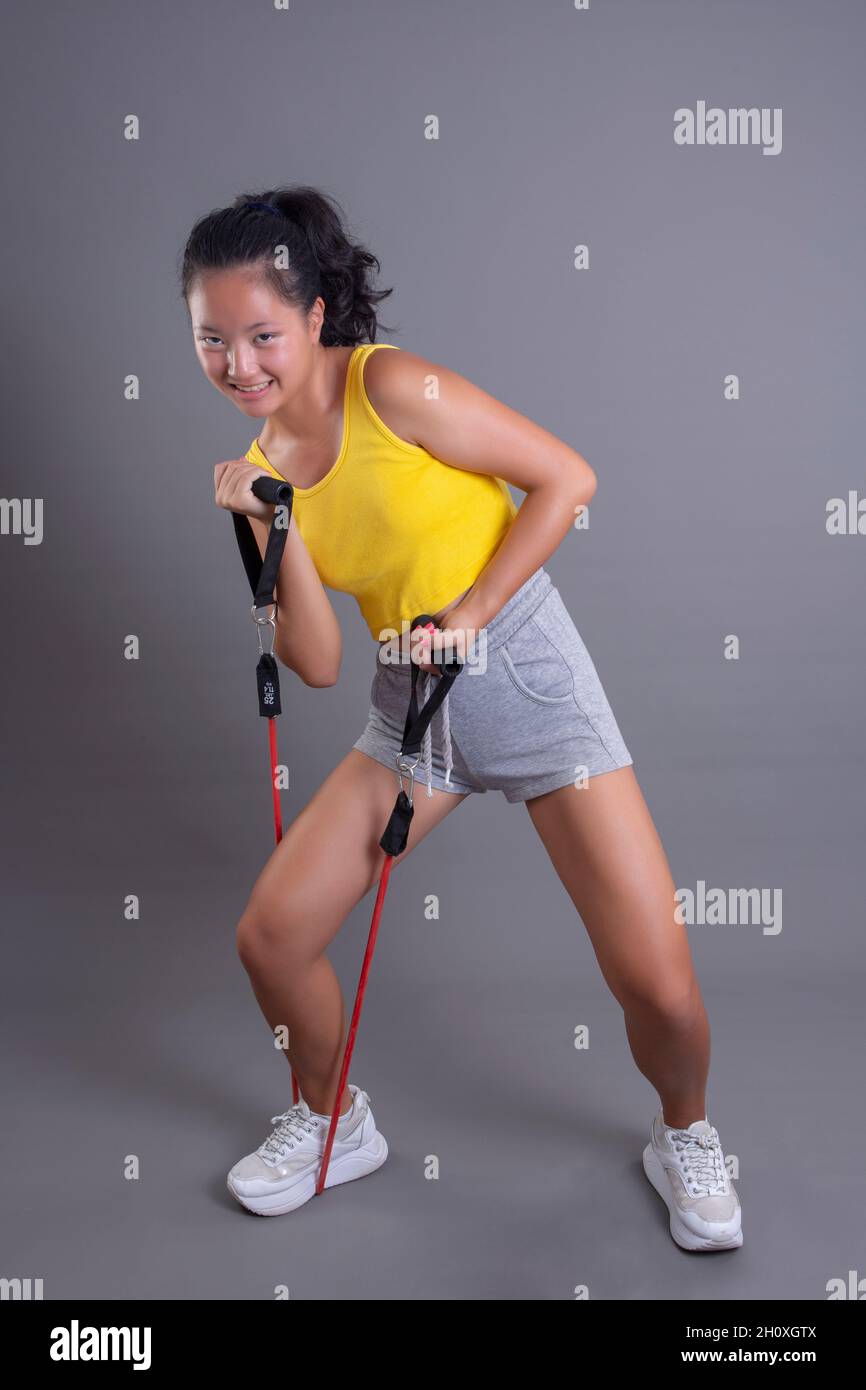 nice and smiling Chinese girl with rubber resistance bands Stock Photo ...