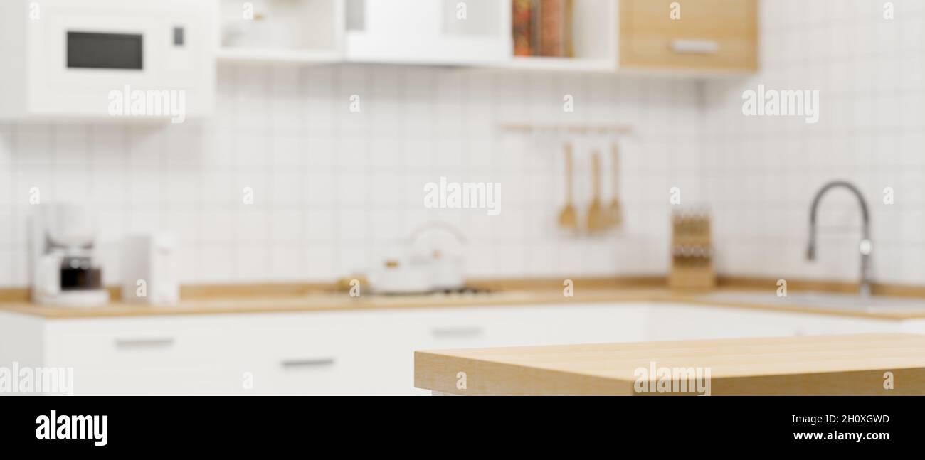 Wooden kitchen counter top on blurry modern white minimalist kitchen ...