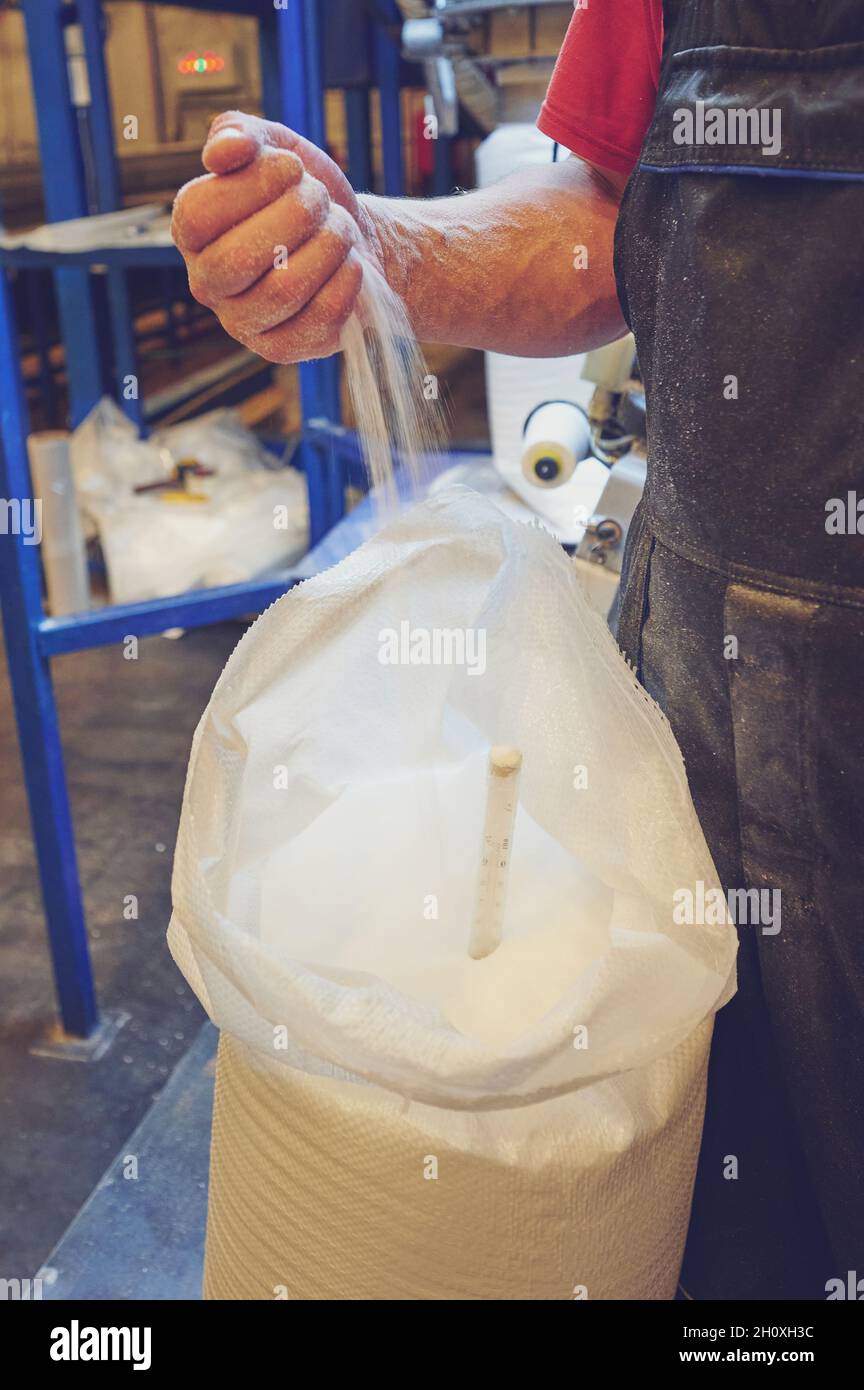 Open white plastic sack with granular in sorting line Stock Photo - Alamy