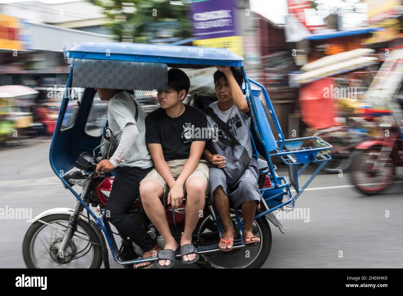 Typical Filipino motor taxi with passengers in the streets of Naga city ...