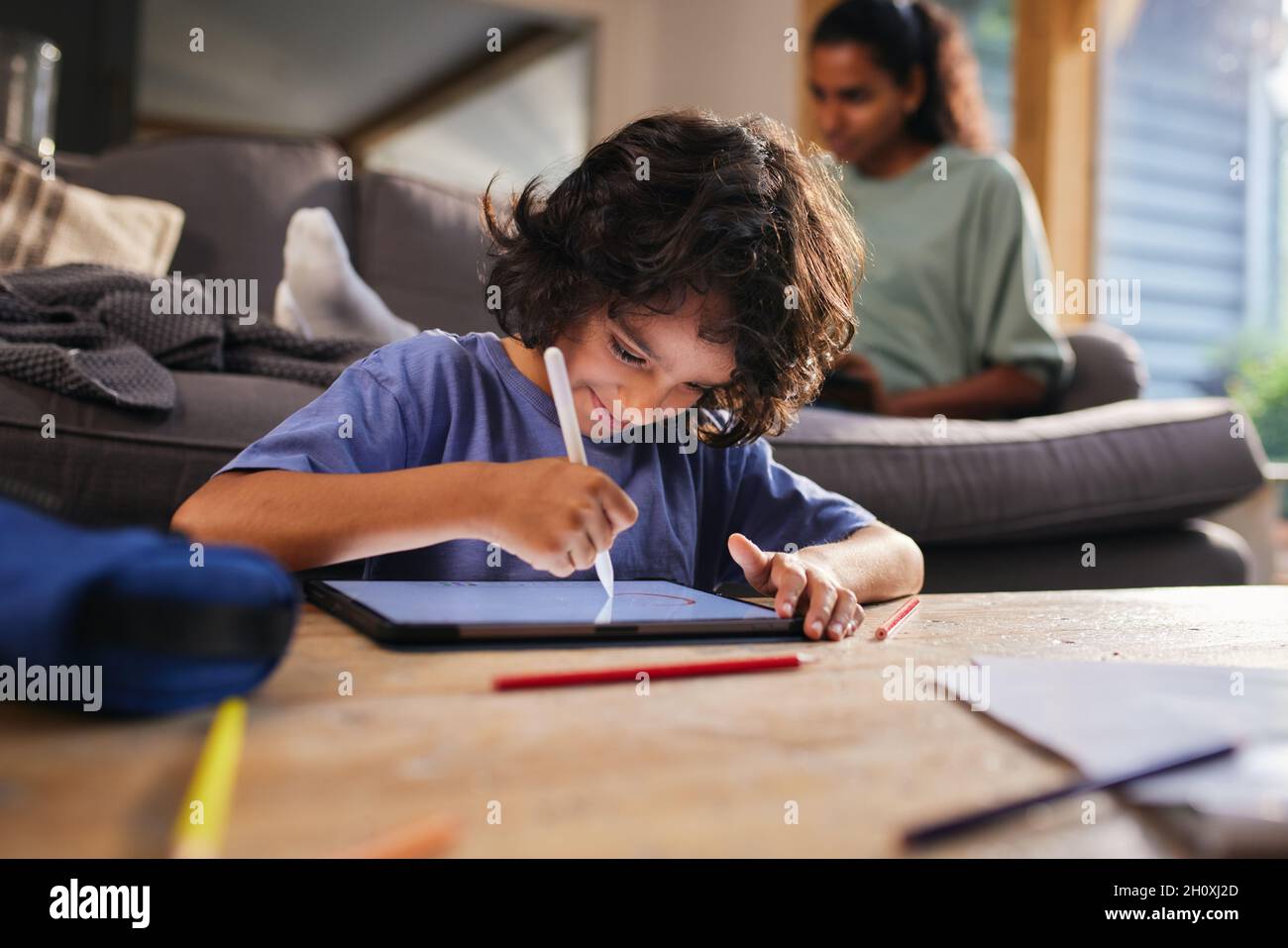Boy drawing on tablet and smiling Stock Photo - Alamy