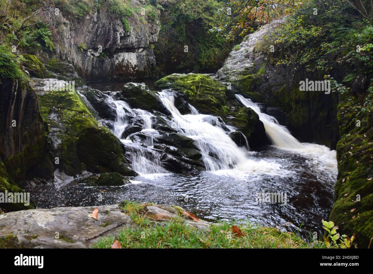 The River Dove cascades over rocks in a silken flow at Beezley falls ...