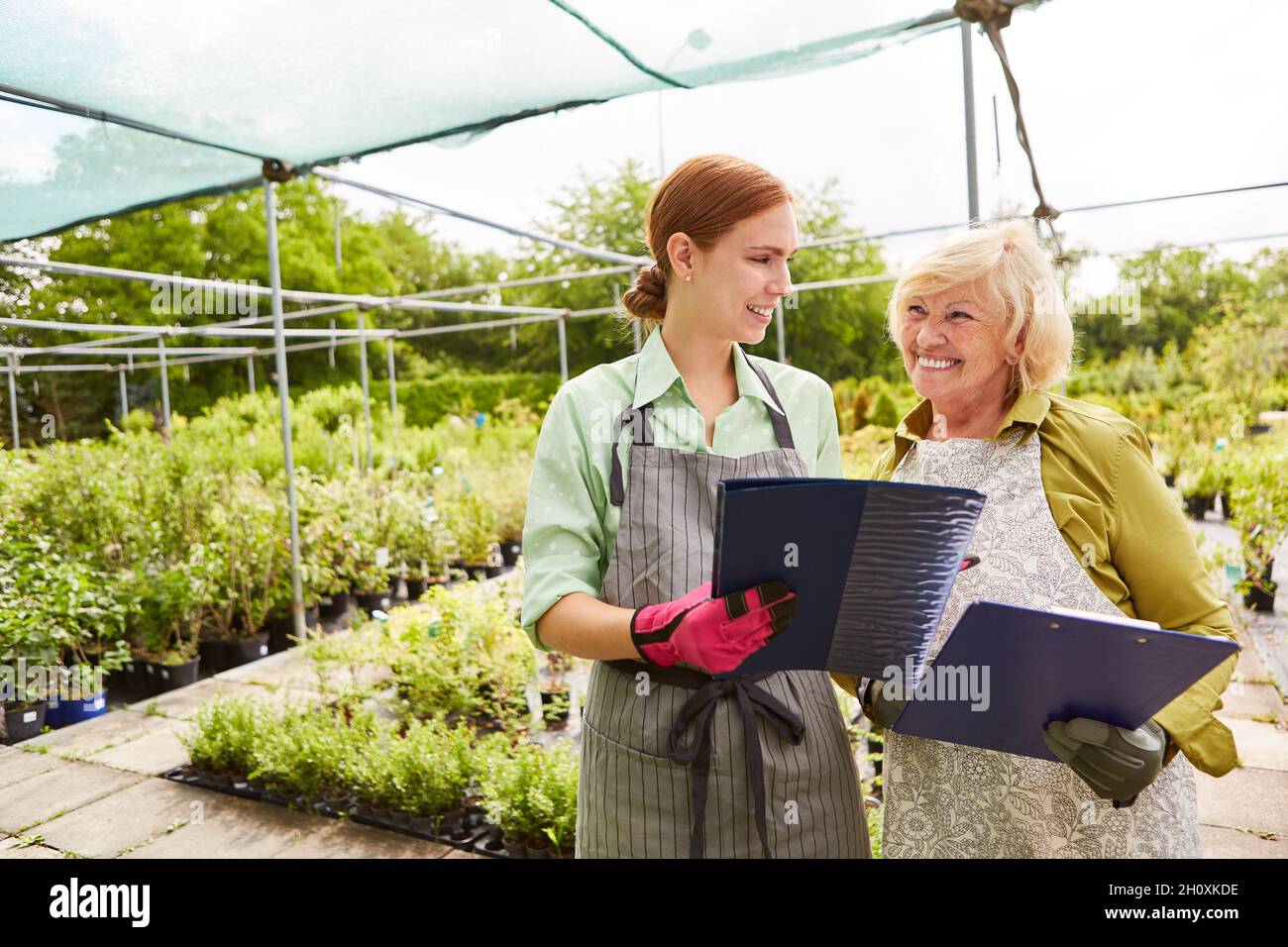 The gardener as boss and the young florist trainee work together in the ...