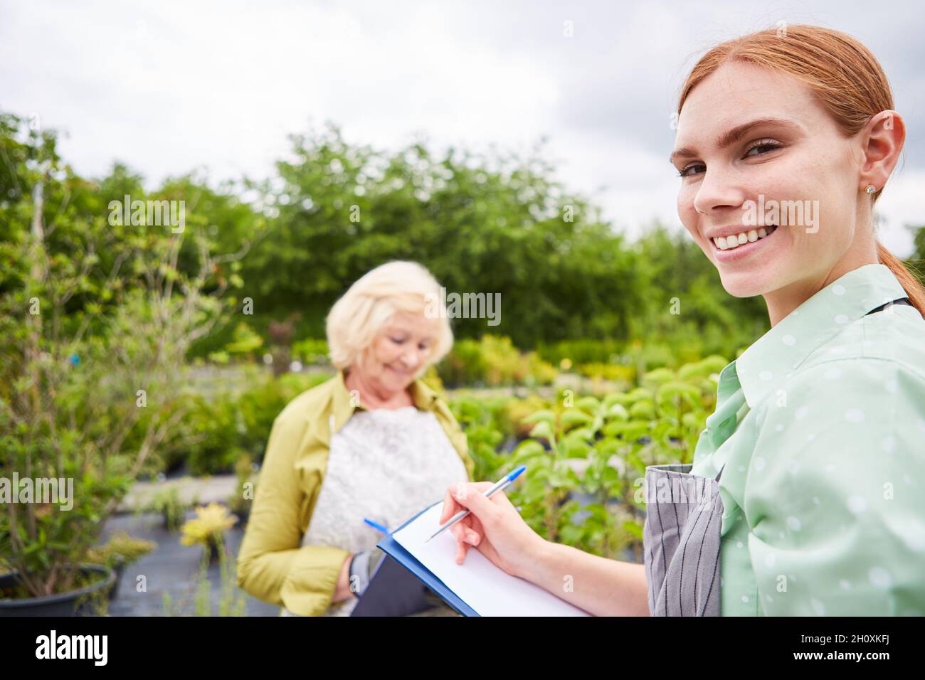 Trainee gardener with checklist and clipboard notes an order in the ...