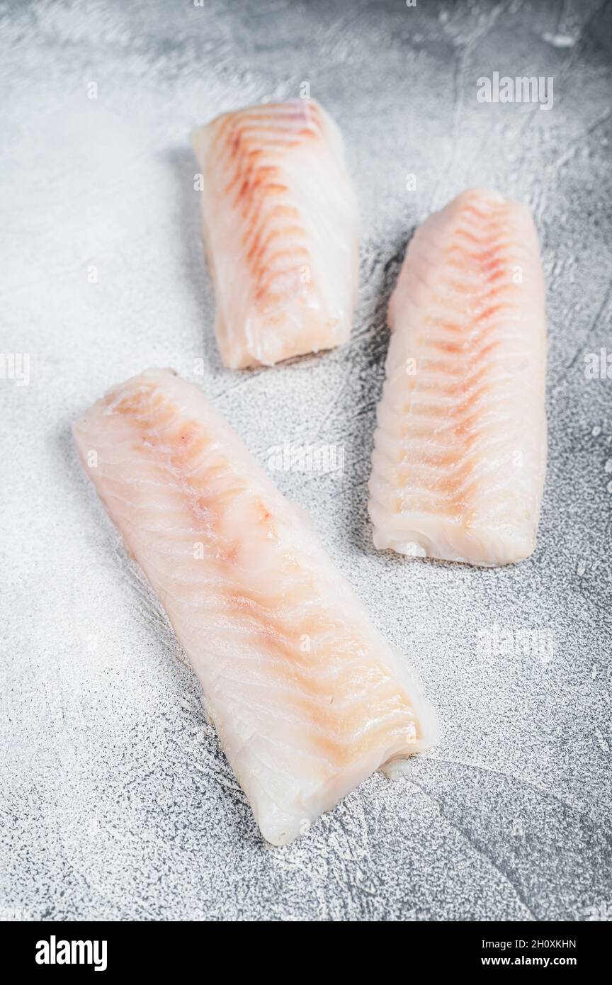 Raw Norwegian cod fish fillet on kitchen table. White background. Top ...