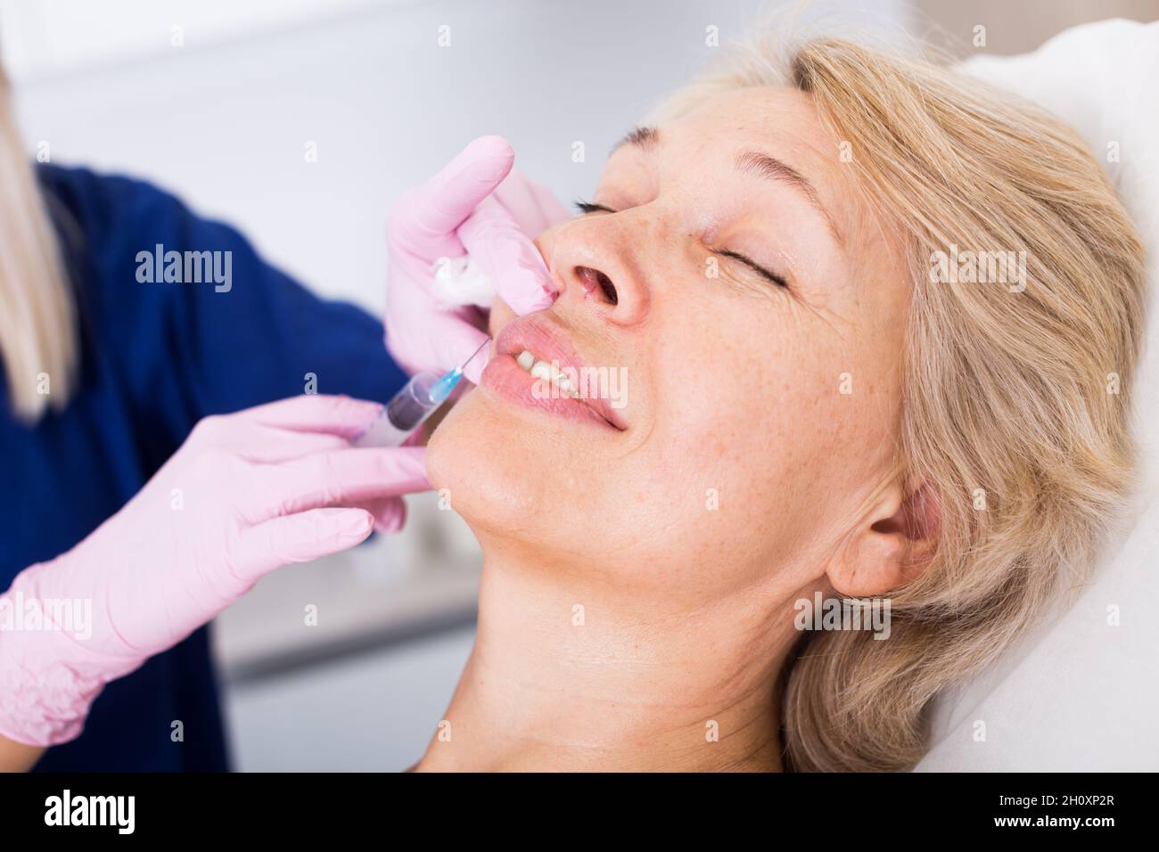 Woman during rejuvenation injections hi-res stock photography and ...