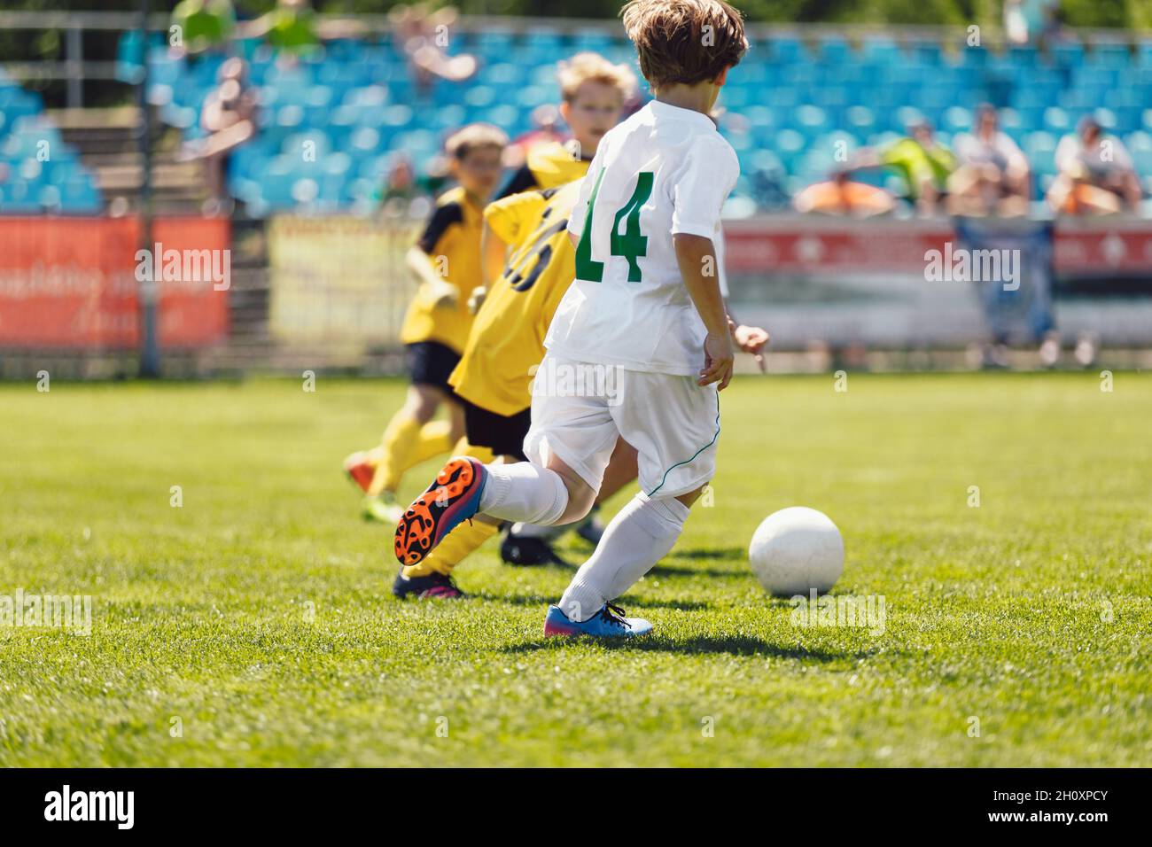 Kids playing football in sunny day. School boys running fast on grass ...