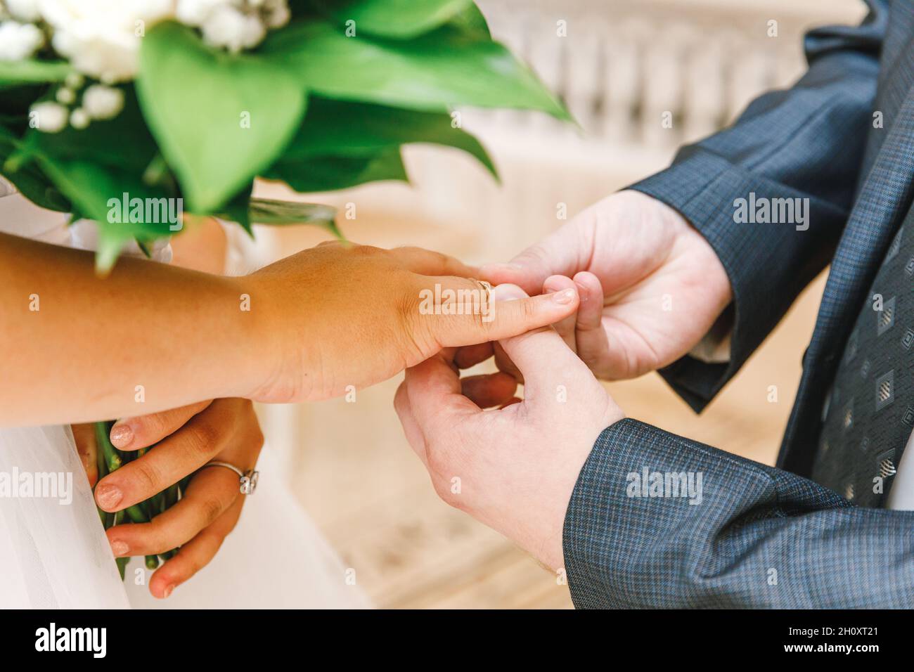 Bride and groom marriage hands with wedding rings. Groom hand putting ...