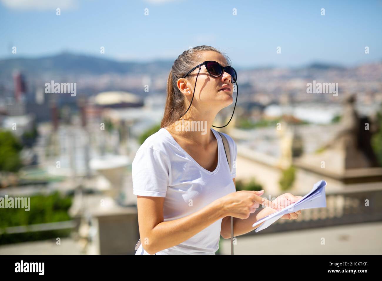 Young woman with paper guide observing sightseeings Stock Photo - Alamy