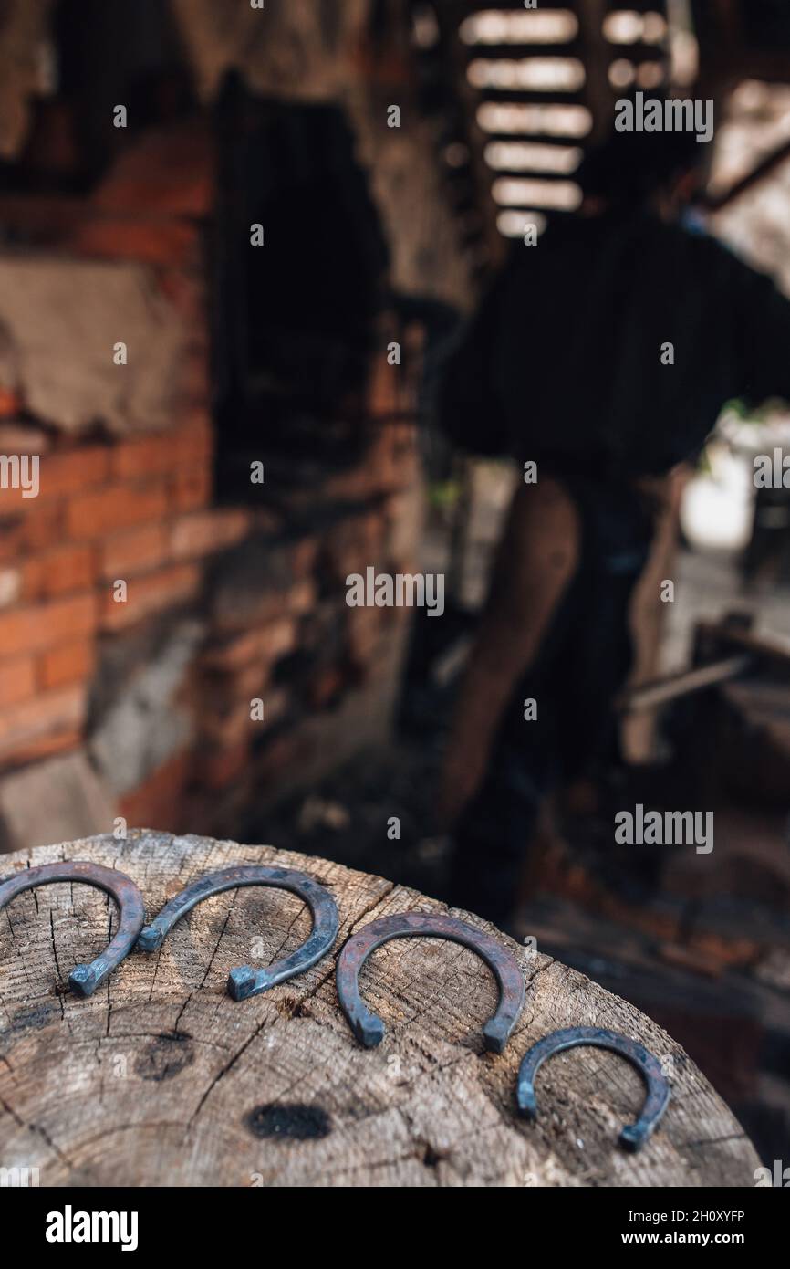 An ancient smithy produces a set of horseshoes for a horse - a ...