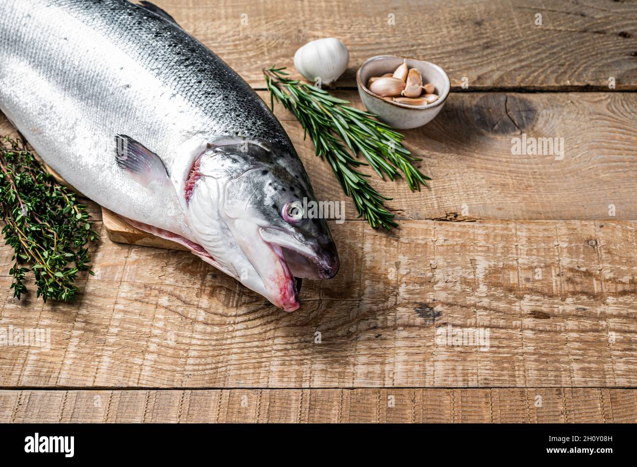 Raw marine salmon fish on a wooden kichen table with herbs. Wooden ...