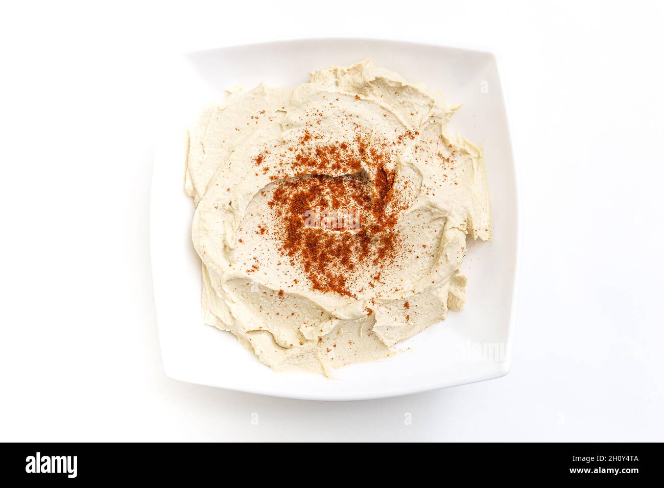 Closeup of humus in a bowl on a white background Stock Photo - Alamy