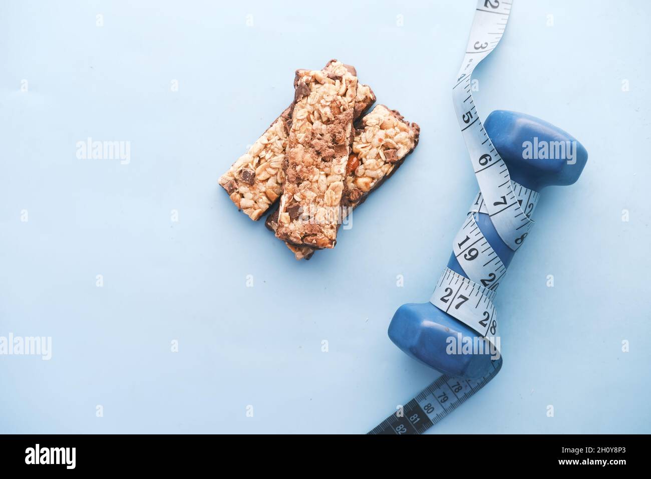 dumbbell, measurement tape and oat protein bars on table Stock Photo ...