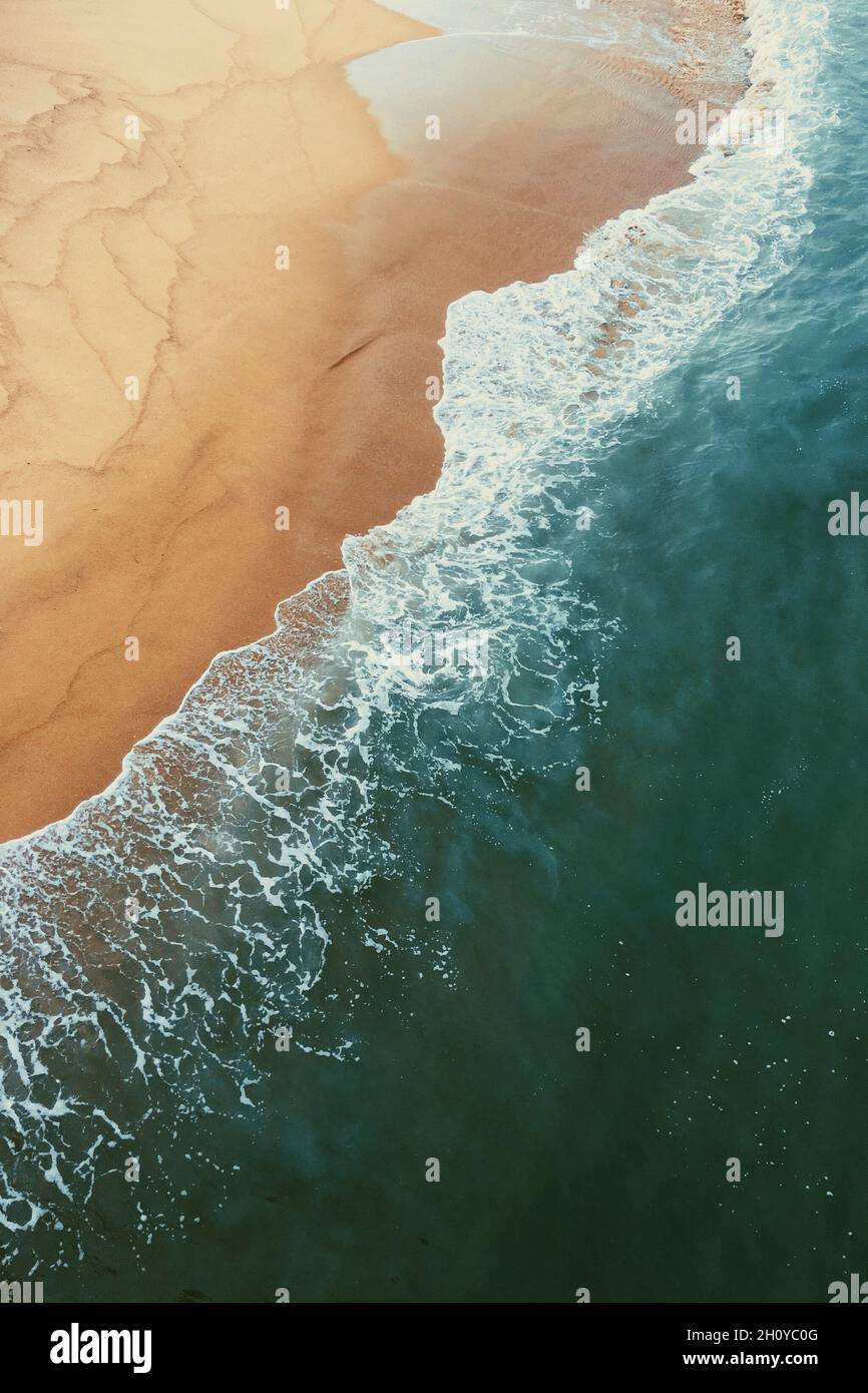 Vertical aerial view of a wavy coast with soft sand - nature Stock ...