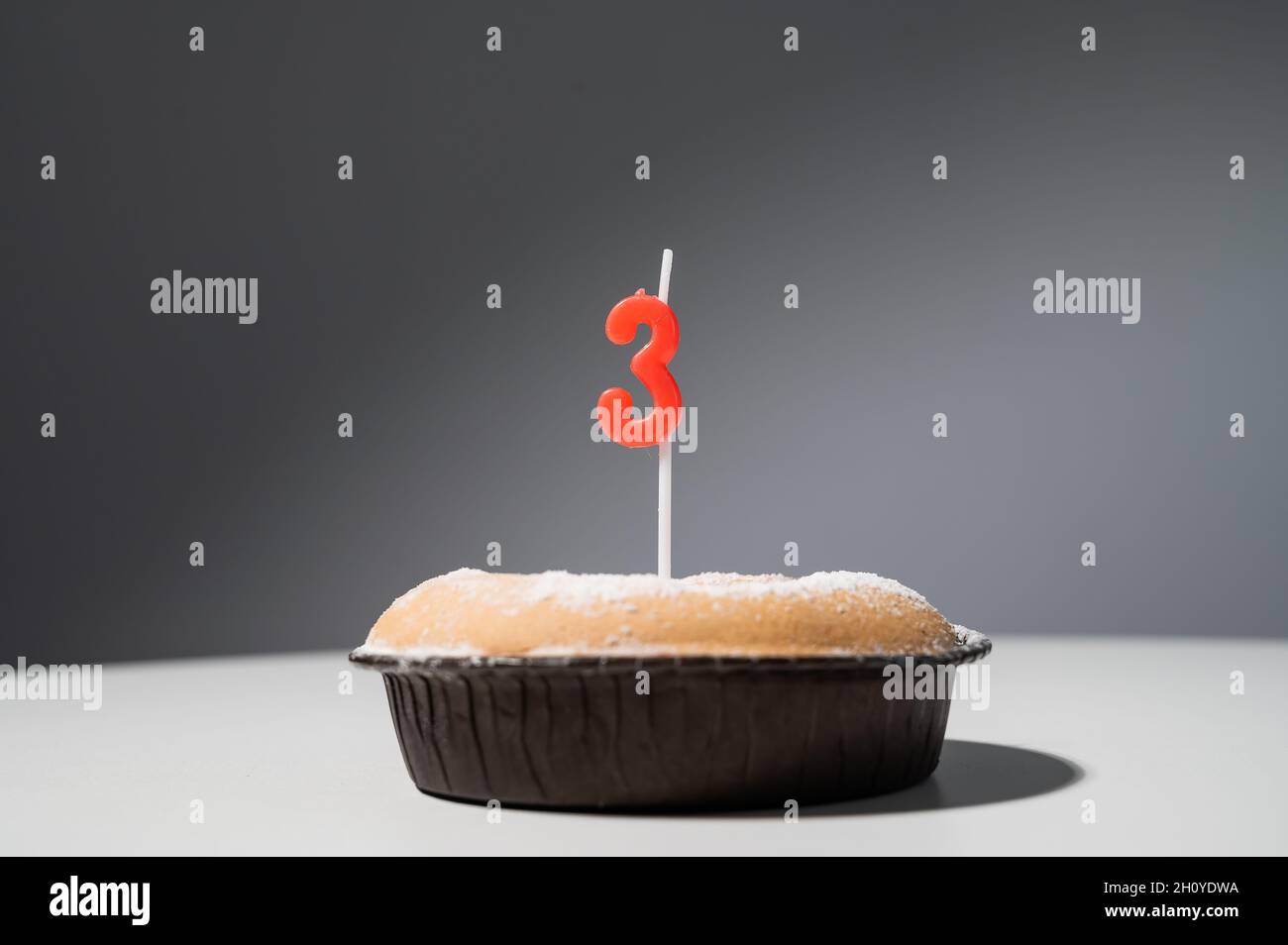 small cake with a candle in the shape of the number three for birthday ...