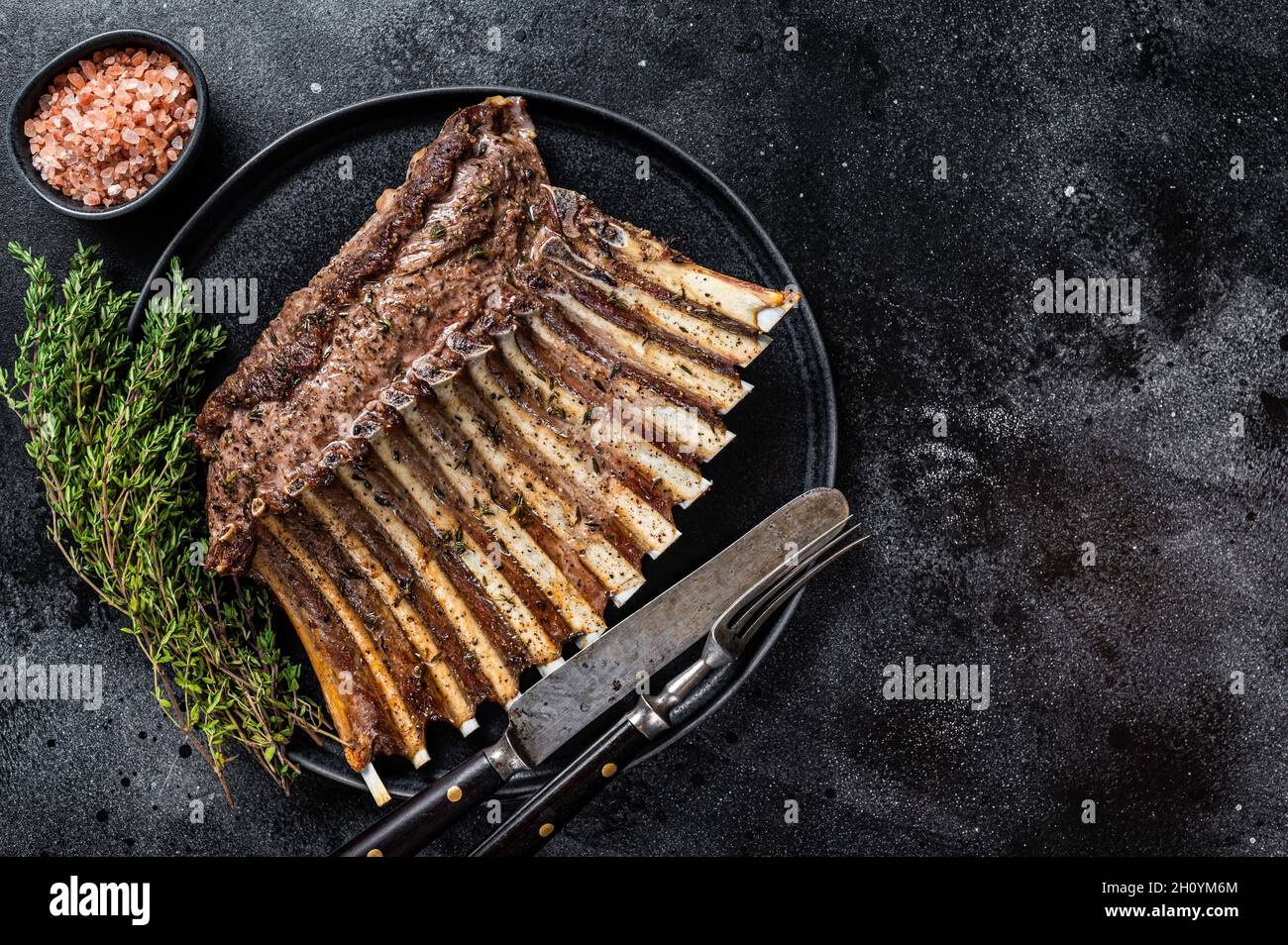 BBQ Grilled rack of Lamb mutton Ribs Chops on plate with thyme. Black ...