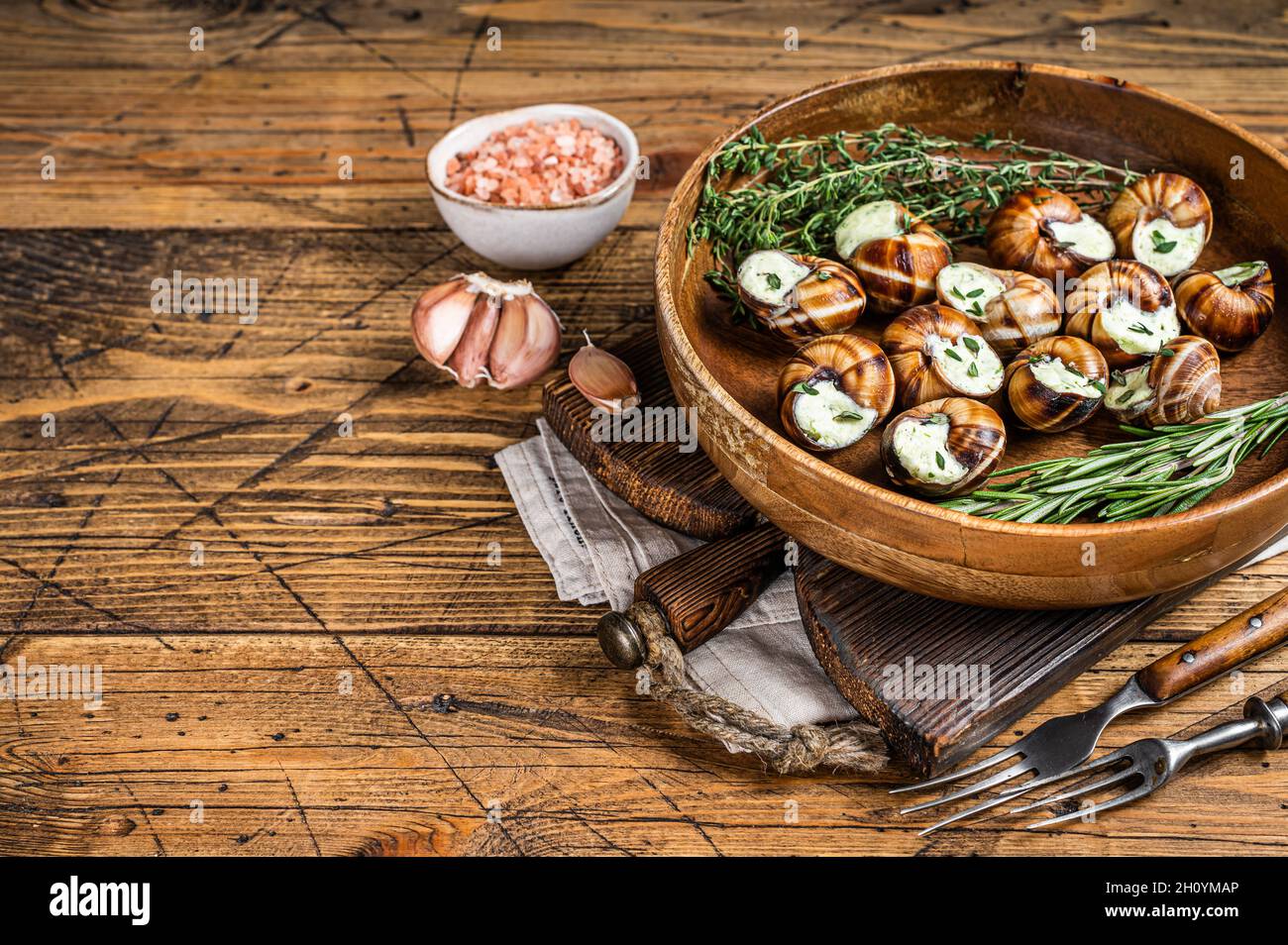 French Escargot Snails with garlic butter in a wooden plate. Wooden ...