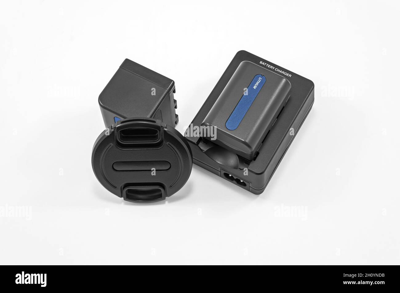 Charger, lithium-ion batteries and camera lens cap made of black ...