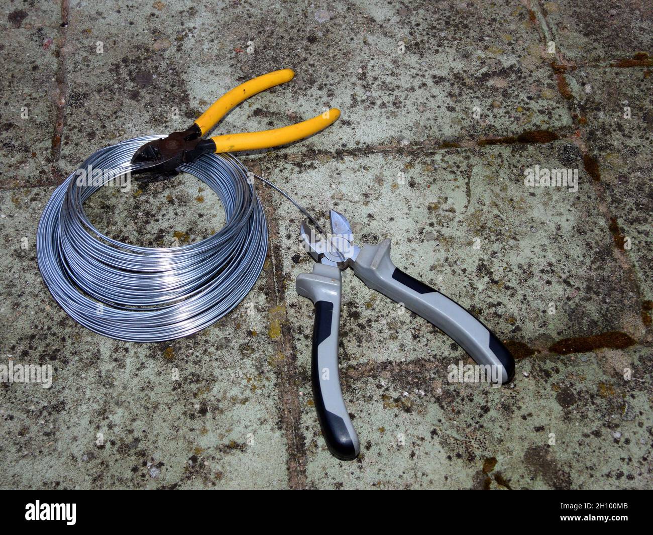 Top view of two pliers and wires on the ground Stock Photo - Alamy