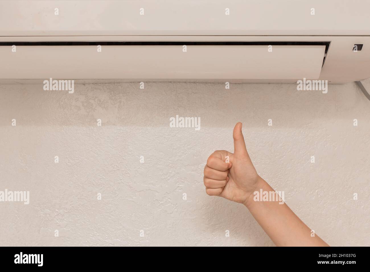 The girl's hand shows the class thumbs up under air conditioner on the ...