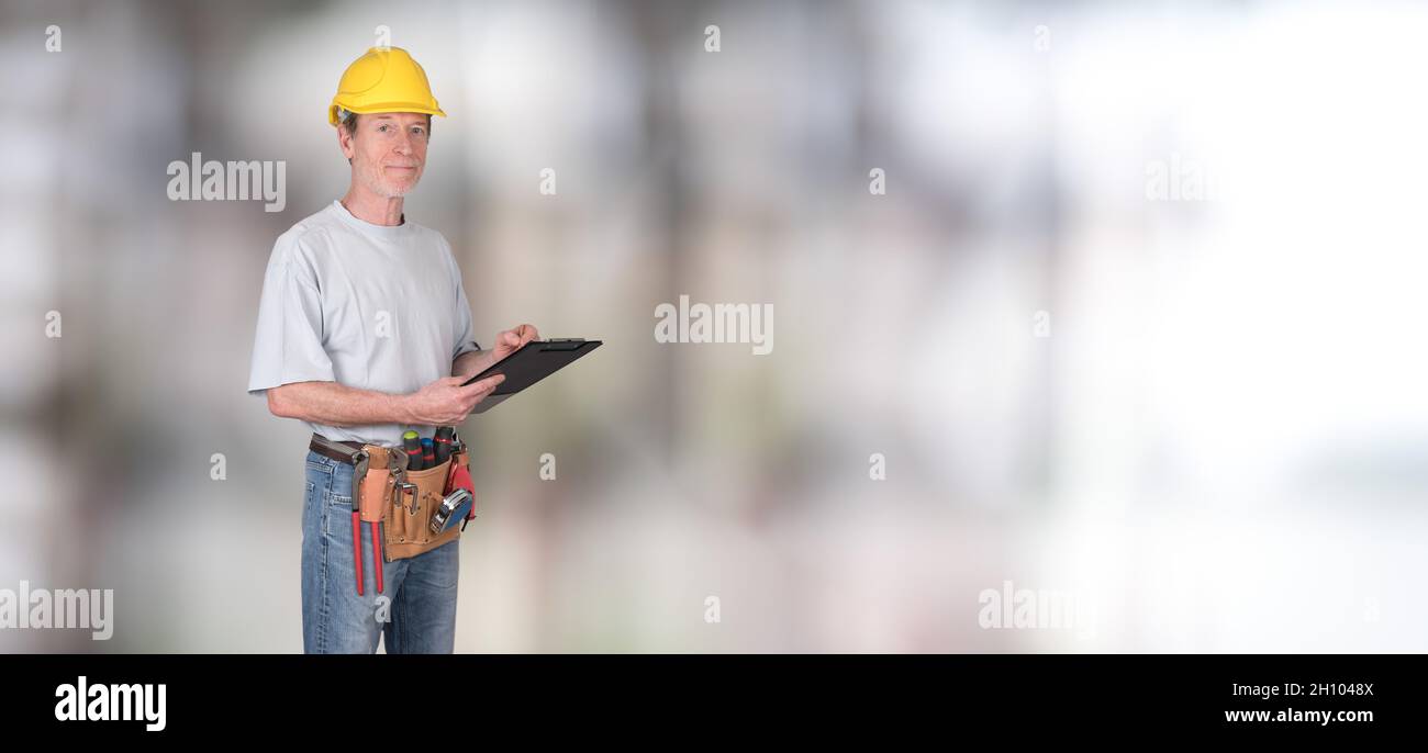 Building worker with tool belt taking notes on blurred background Stock ...