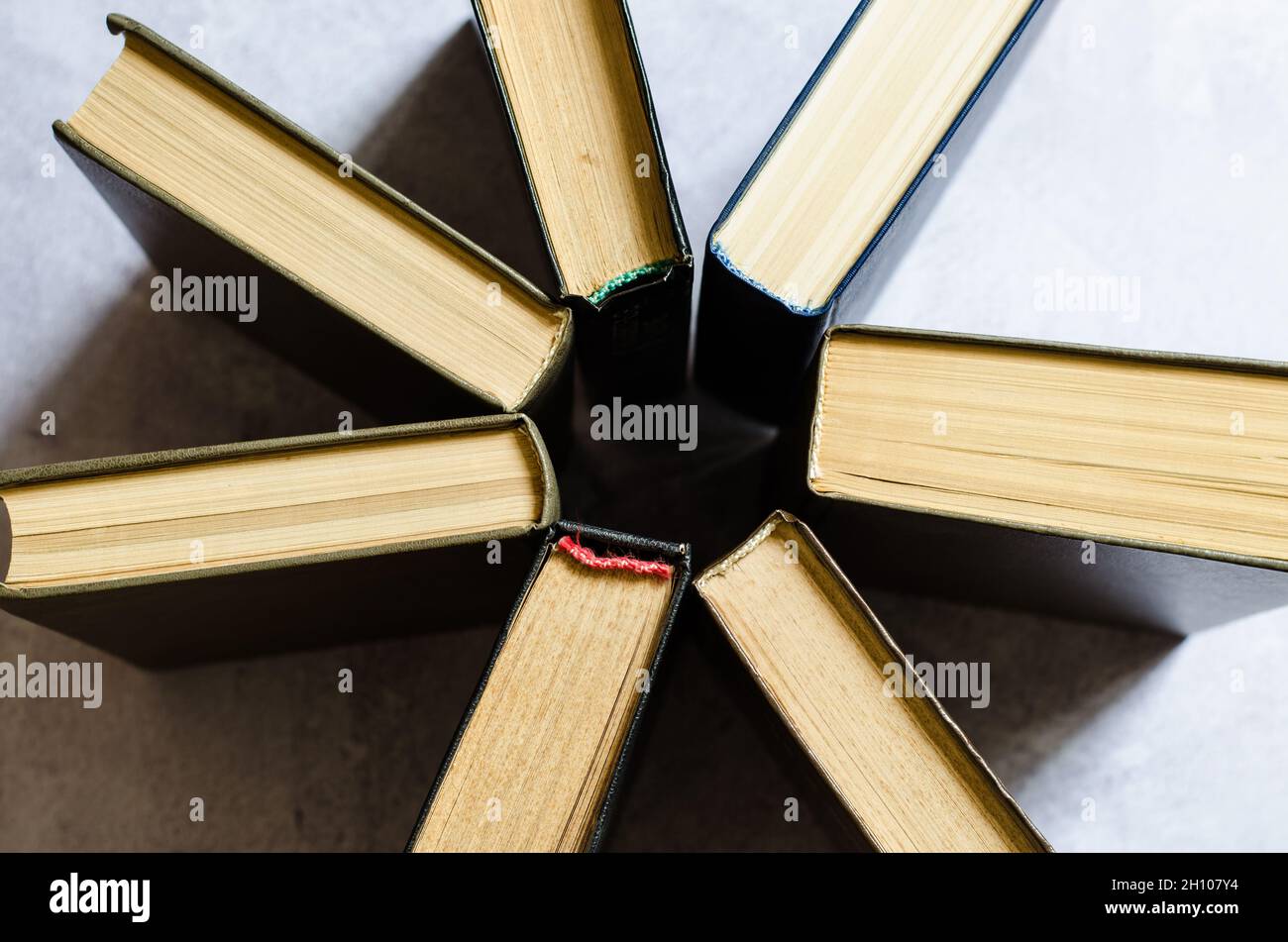 Books with multi-colored covers are stacked in a circle top view ...