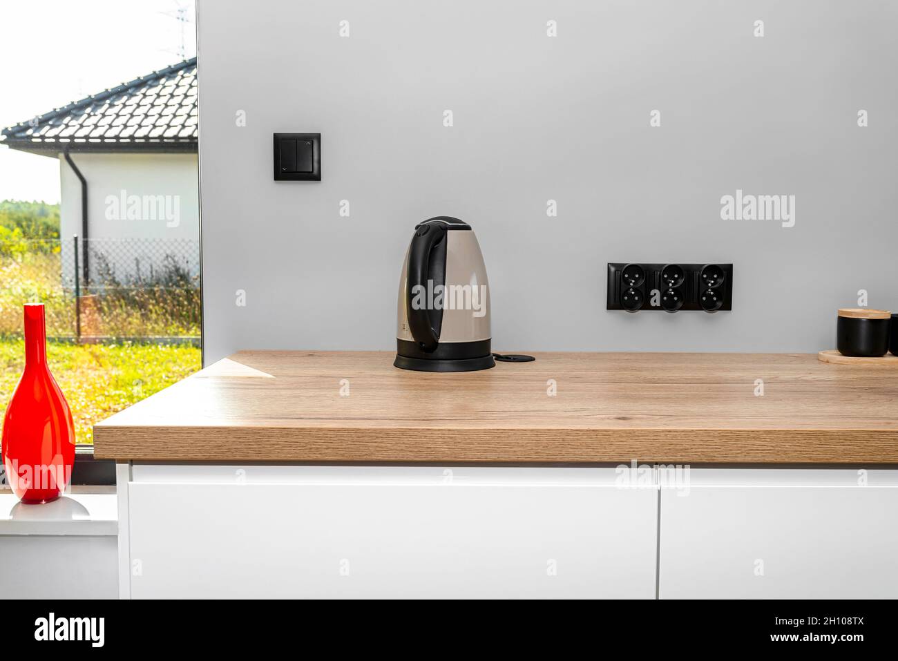 An electric kettle standing on the countertop on the kitchen cabinets ...
