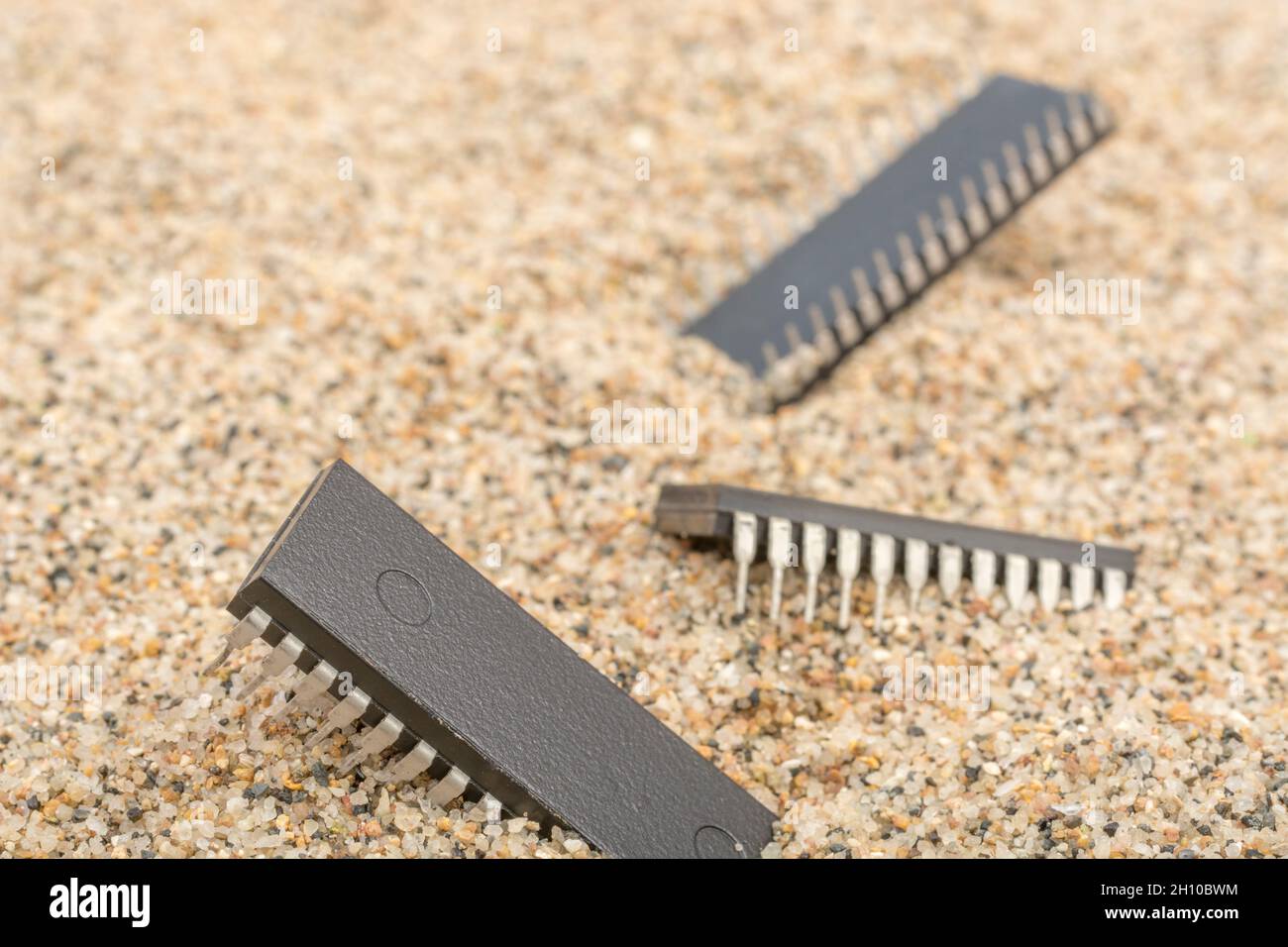 Microchips or IC (integrated circuit) chips buried in sand. For IC ...