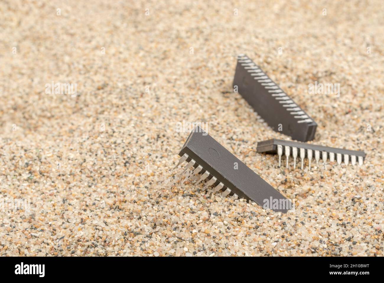 Microchips or IC (integrated circuit) chips buried in sand. For IC ...