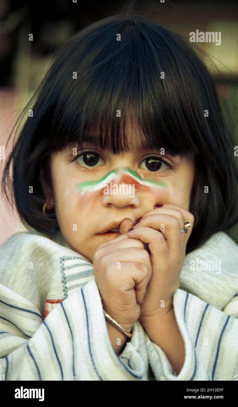 Portrait of a little girl with her face painted with Iran flag colours ...