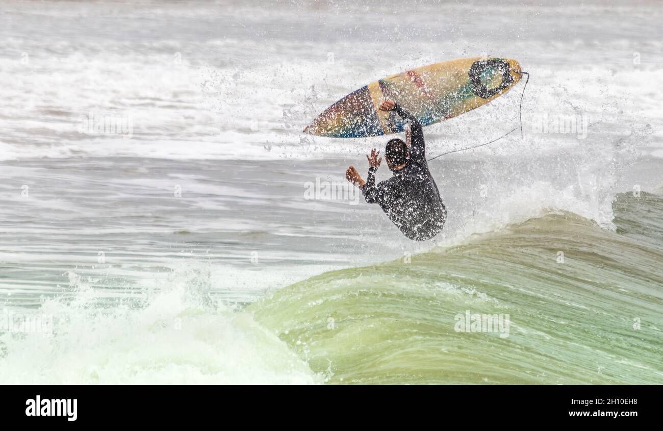 Surfer with the board jumping over the wave Stock Photo - Alamy