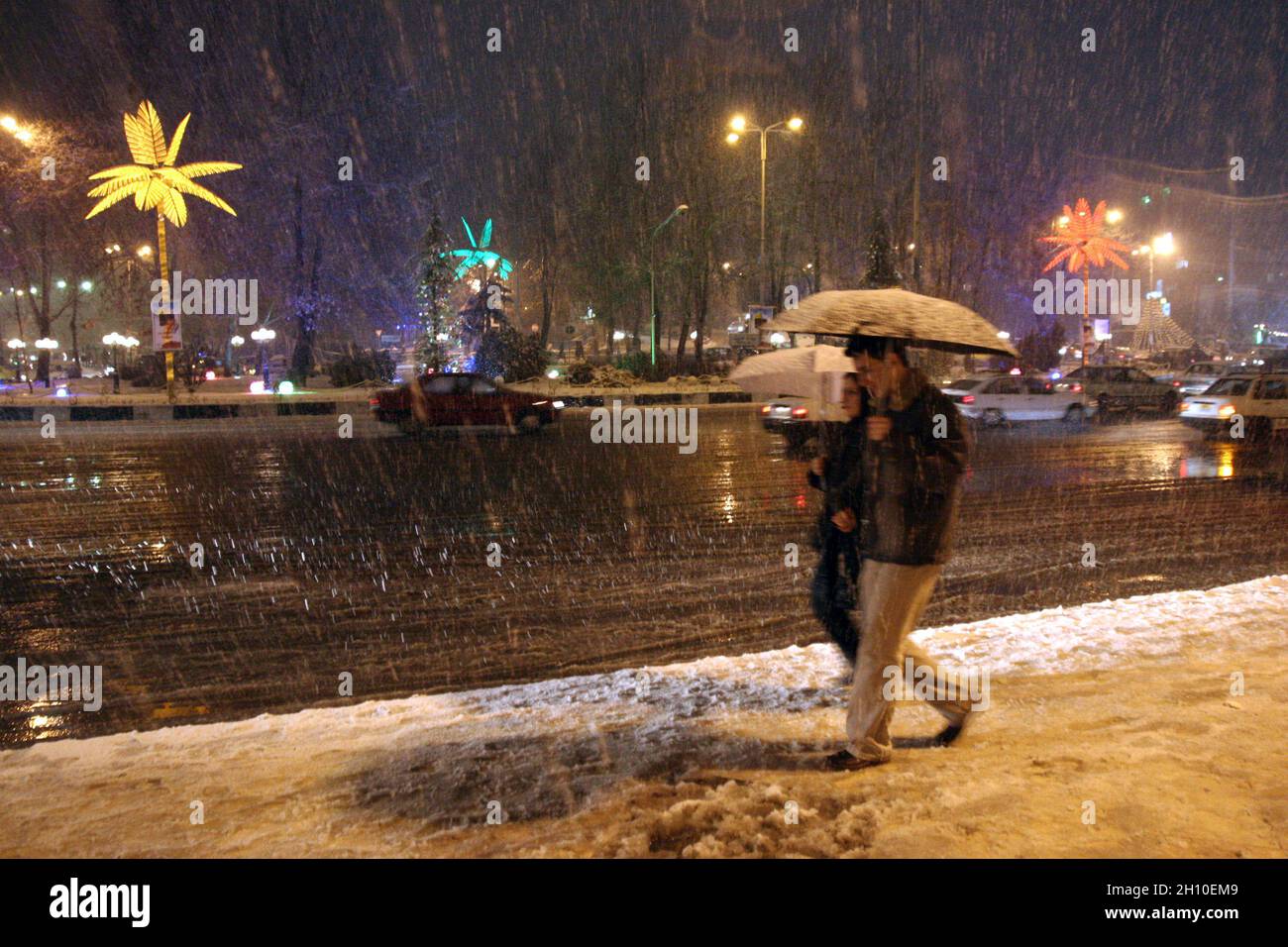 Iranian couple passes under heavy snow in Tajrish SQ. at center of ...