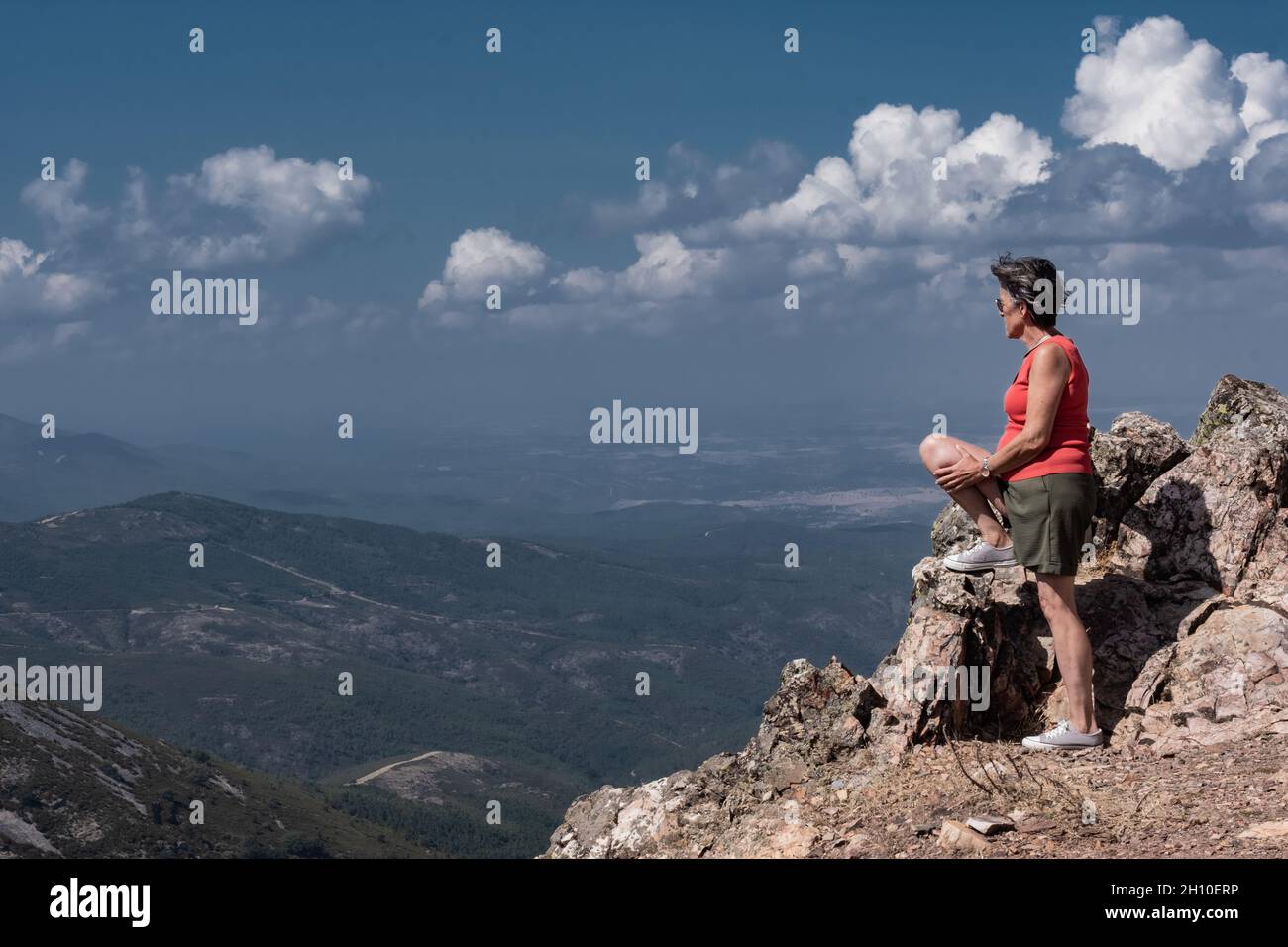 Woman looking down on the valley from a mountain hi-res stock ...