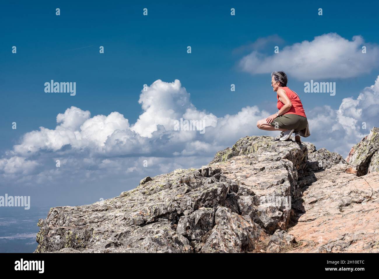 Woman sitting looking down on the valley from a mountain top Stock ...