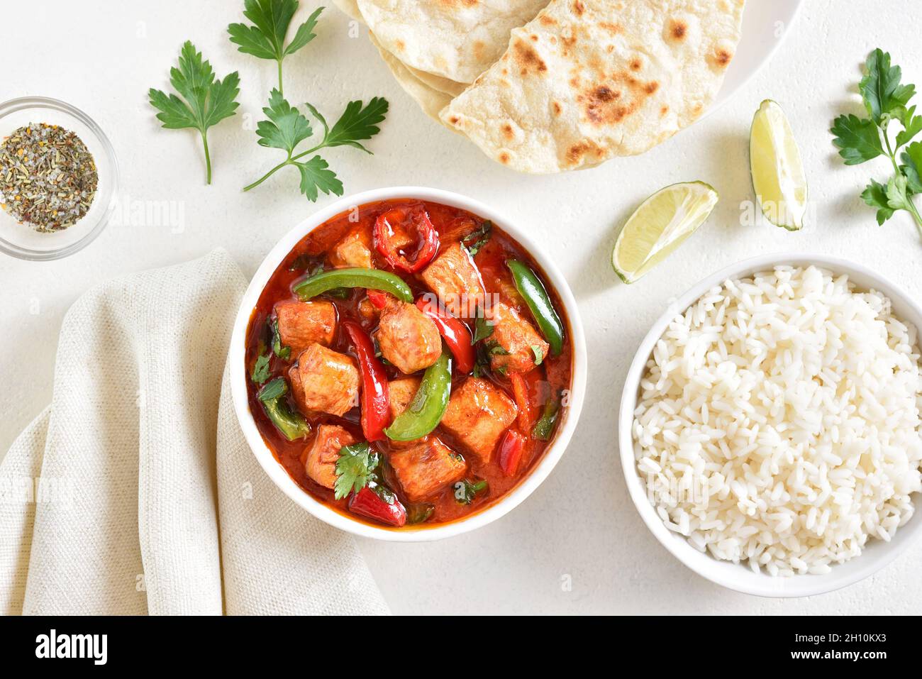 Thai style red chicken curry with vegetables in bowl over light ...