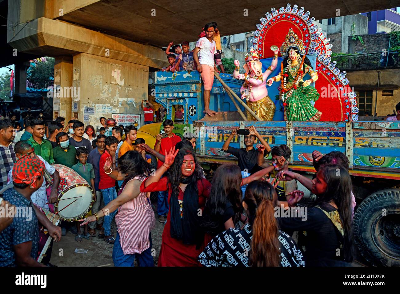 Hindu devotees dance in front of an idol of the Hindu Goddess Durga ...