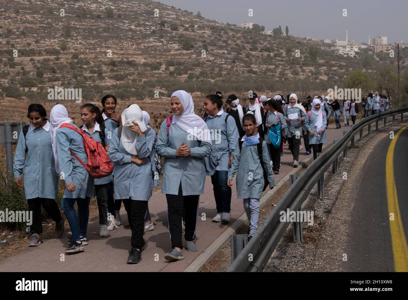 A group of Palestinian schoolgirls walk back home after studies along ...