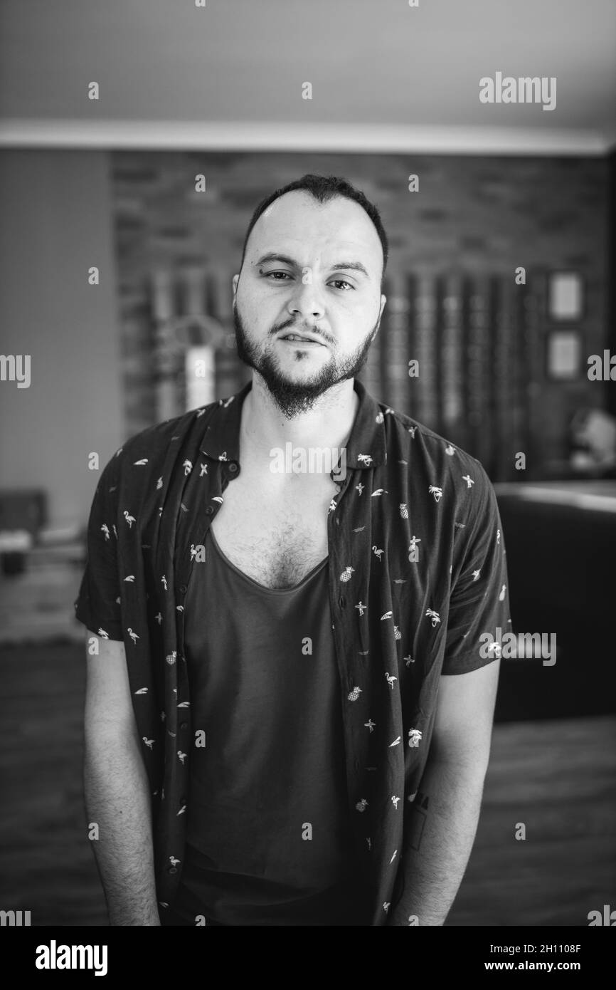 Vertical shot of a Bosnian male standing in a room / Grayscale Stock ...