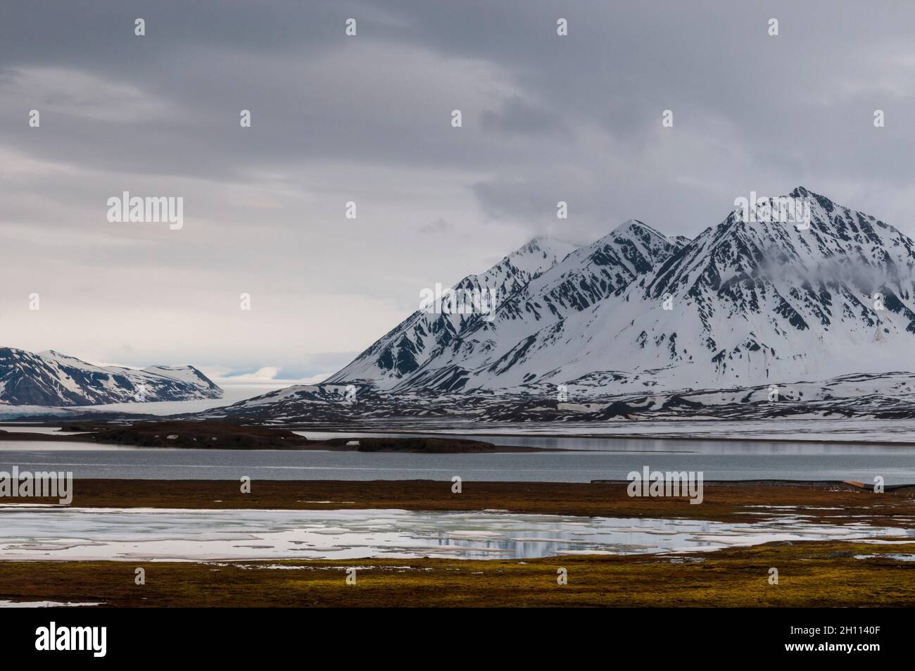 A scenic view of mountains and arctic waters at Ny-Alesund on ...