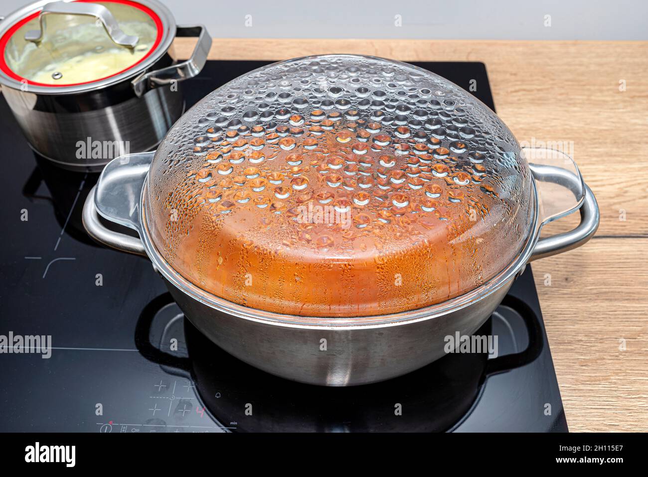 Steel pots with a cooking dish on an induction cooker built into the ...