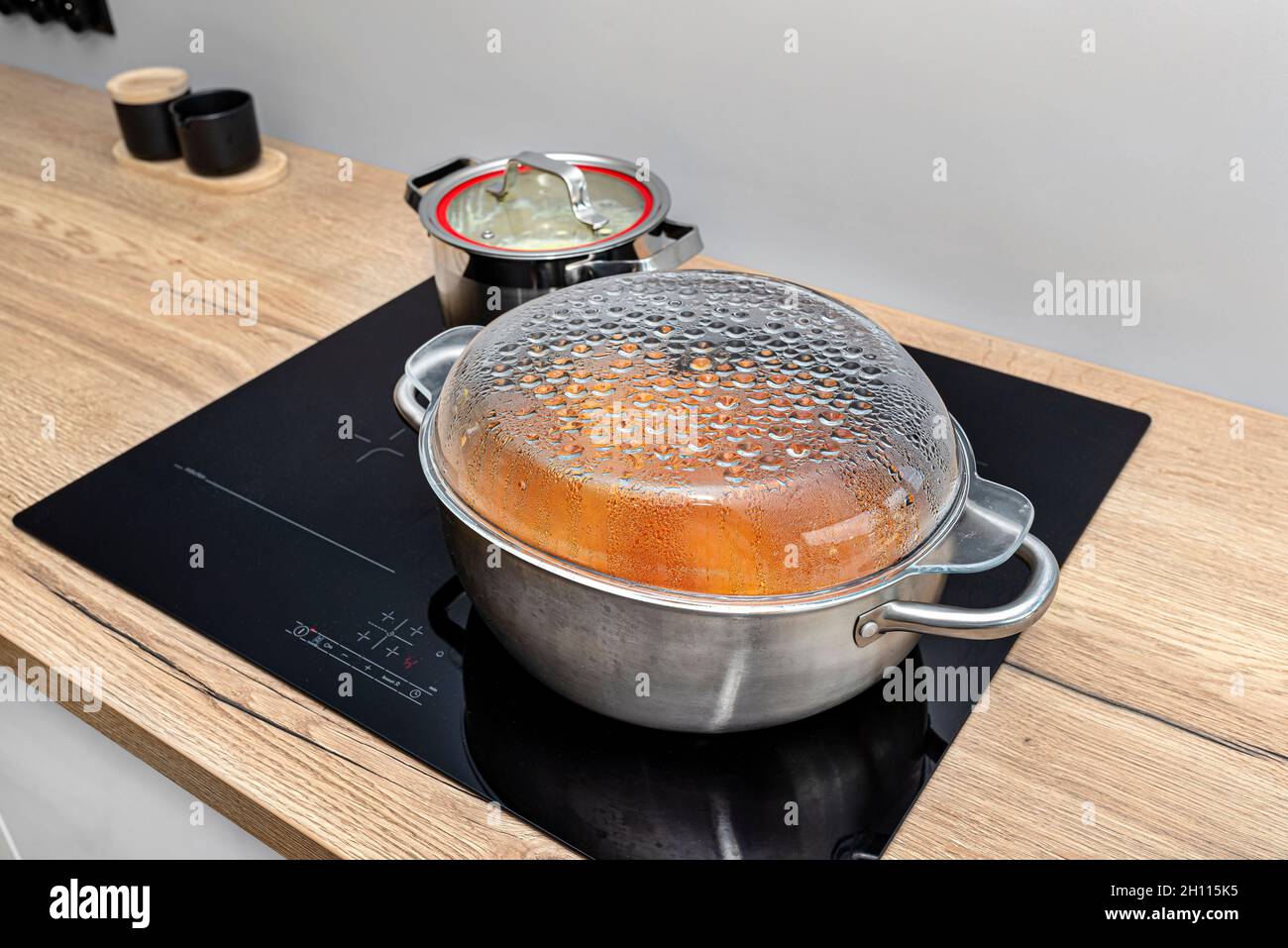 Steel pots with a cooking dish on an induction cooker built into the ...