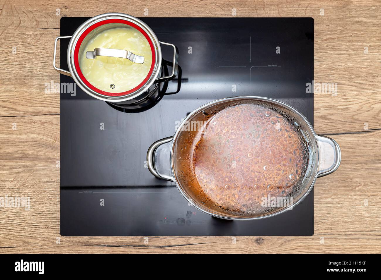 Steel pots with a cooking dish on an induction cooker built into the ...