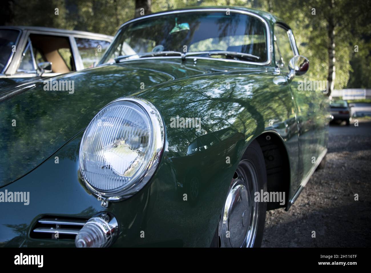 closeup partial view of the front and headlight of a classic green ...