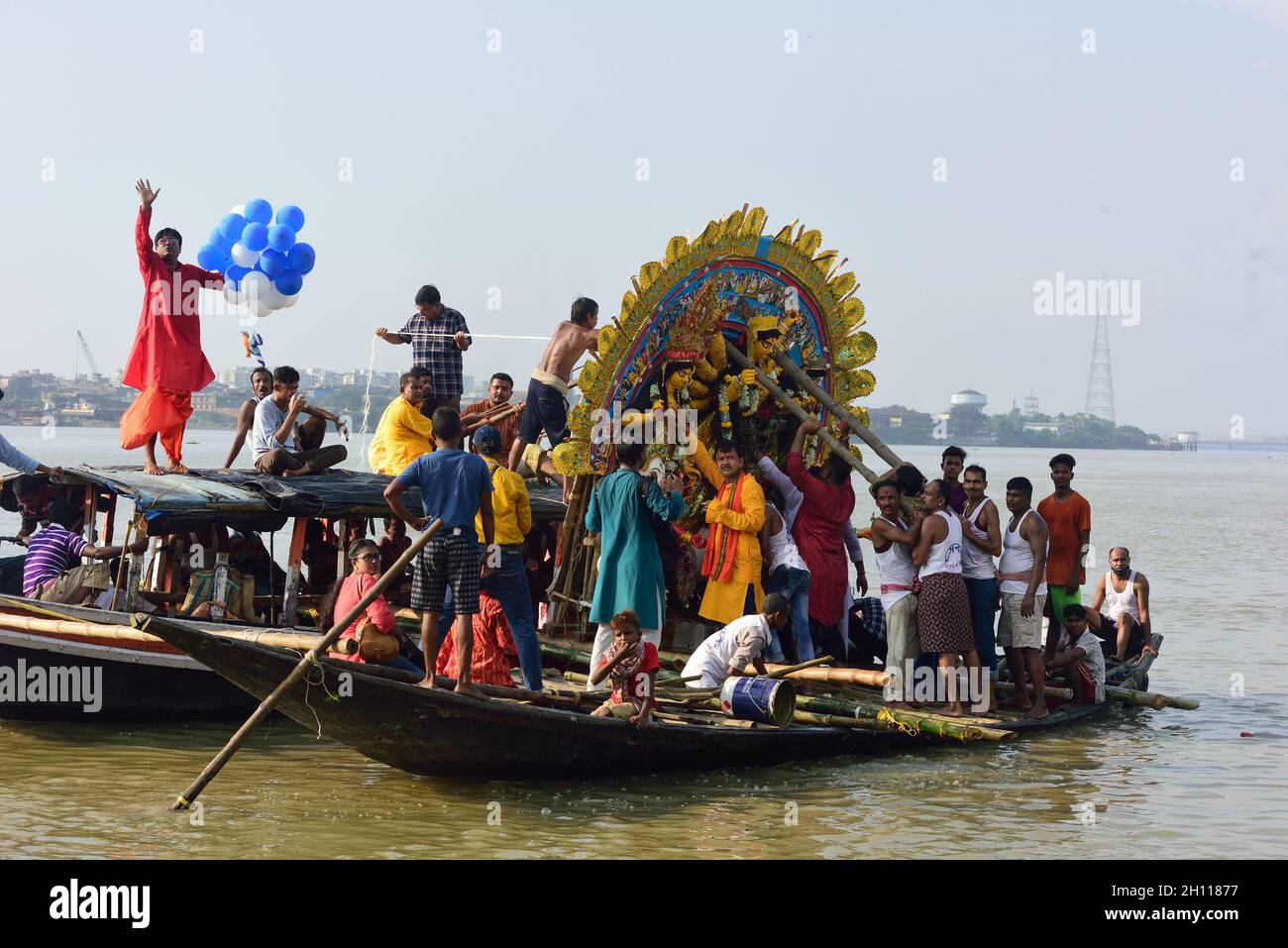 Devotees on boats taking an idol for immersion, during the ritual ...