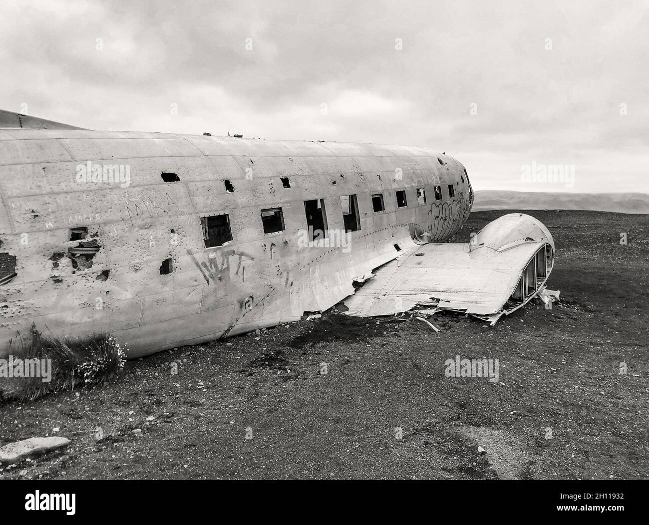 Breathtaking shot of a plane after a crash on the ground in grayscale ...