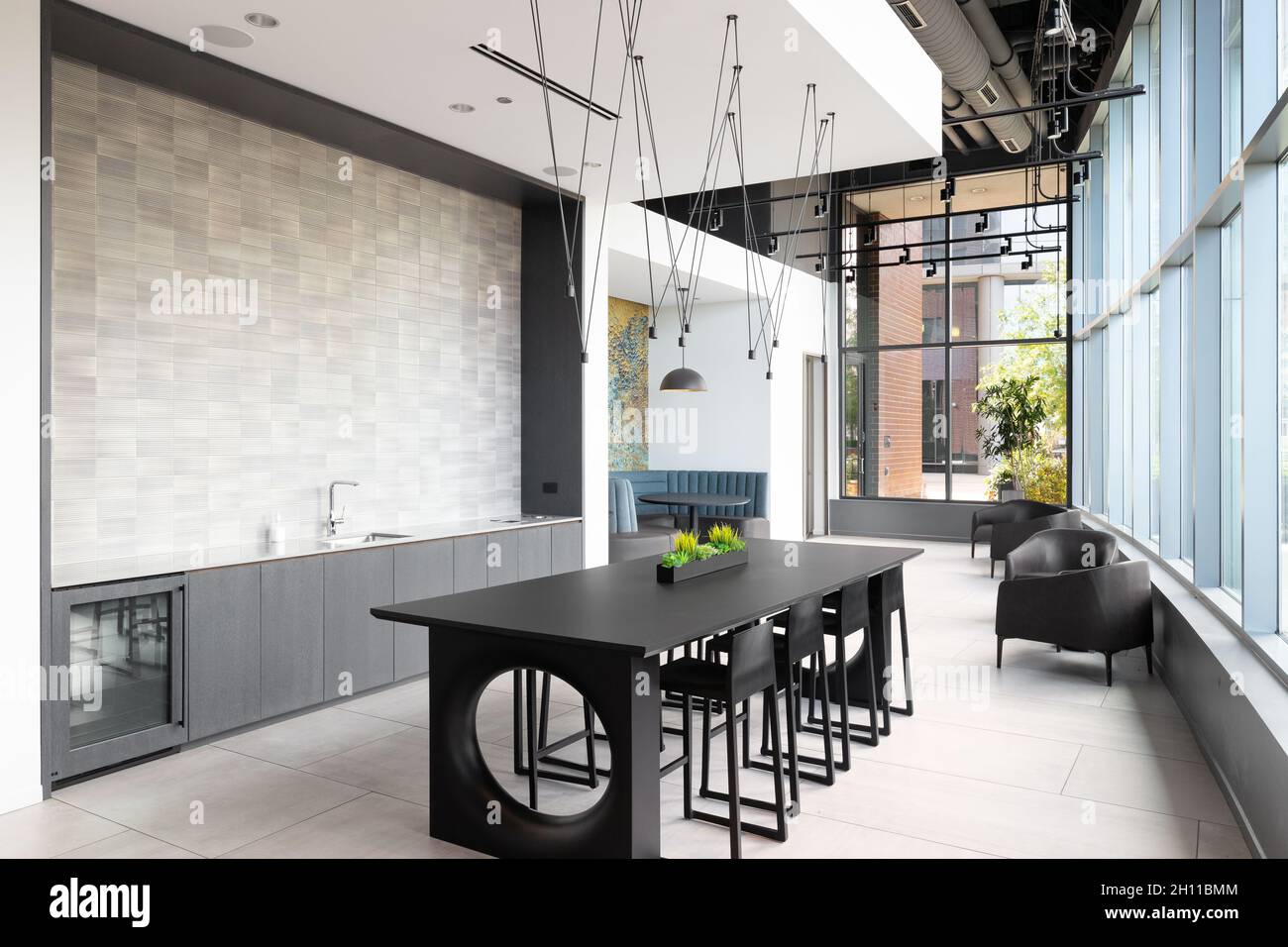 A modern and cozy entertaining space with a fancy light fixture over ...