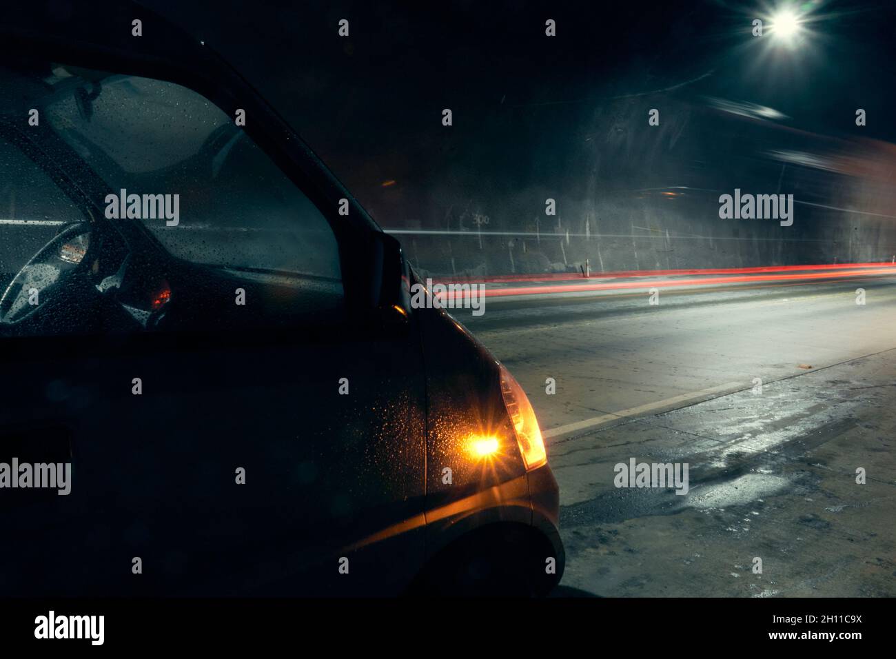 Side view of a minivan in the tunnel at night with headlights on Stock ...