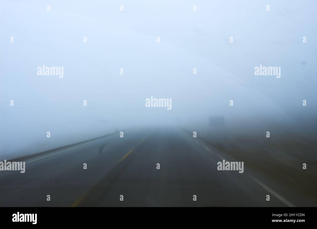 Empty straight country lane lost in the fog, horizontal background ...
